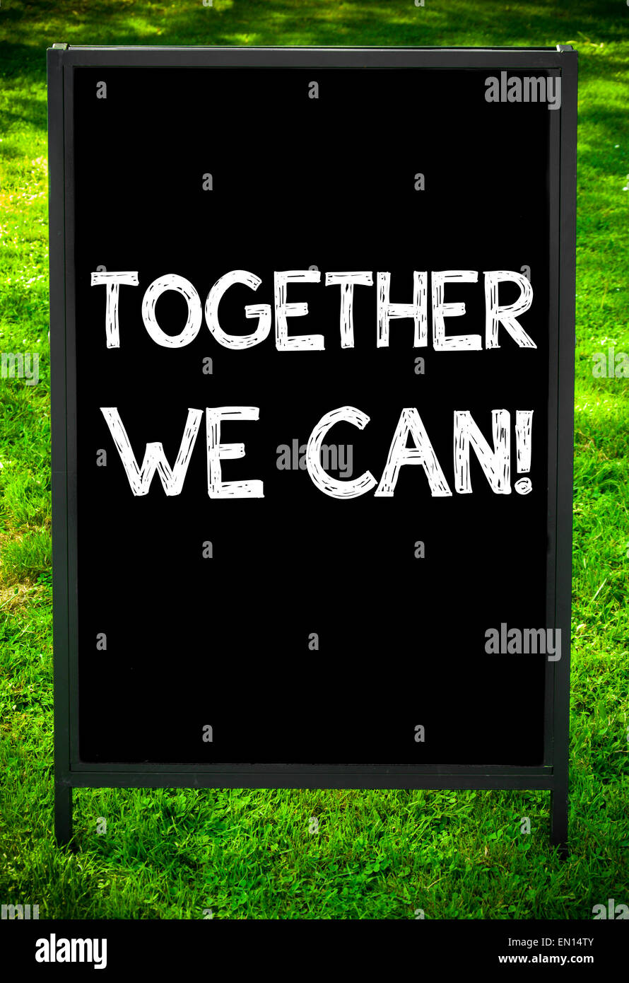 TOGETHER WE CAN message on sidewalk blackboard sign against green grass ...