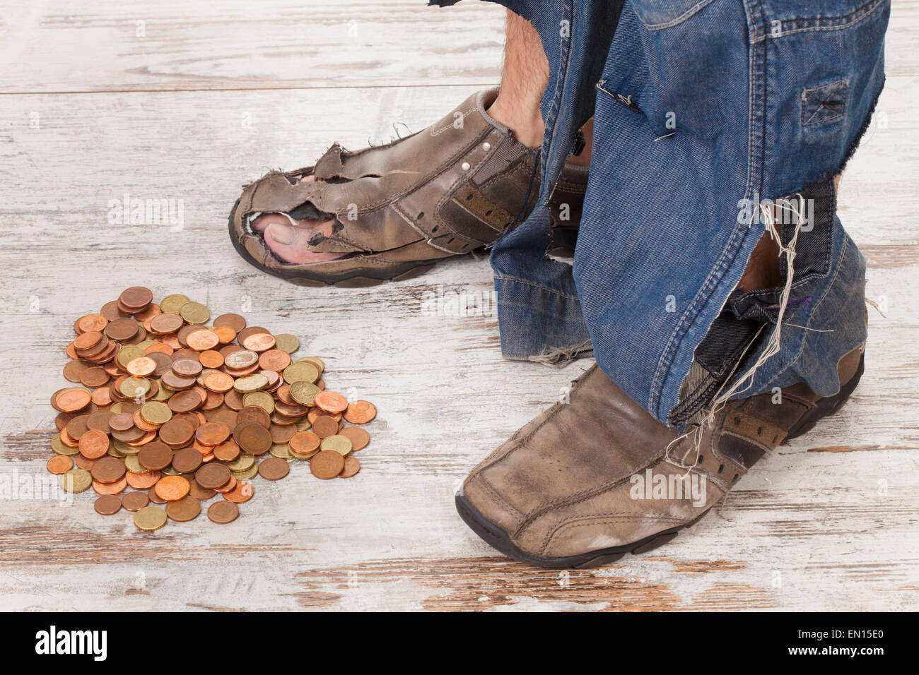 concept of a poor person and his feet with some coins Stock Photo - Alamy