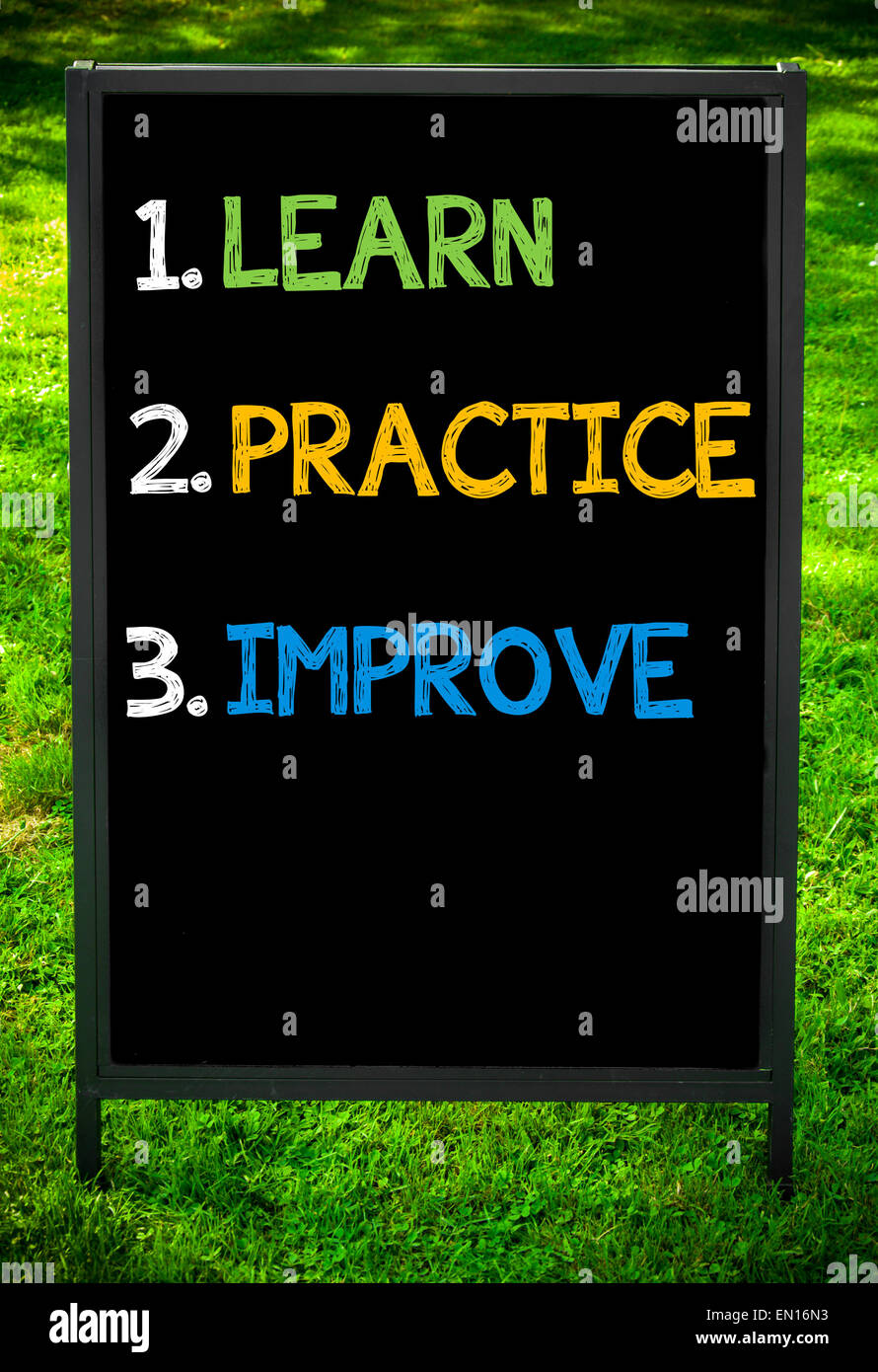 LEARN, PRACTICE, IMPROVE message on sidewalk blackboard sign against ...