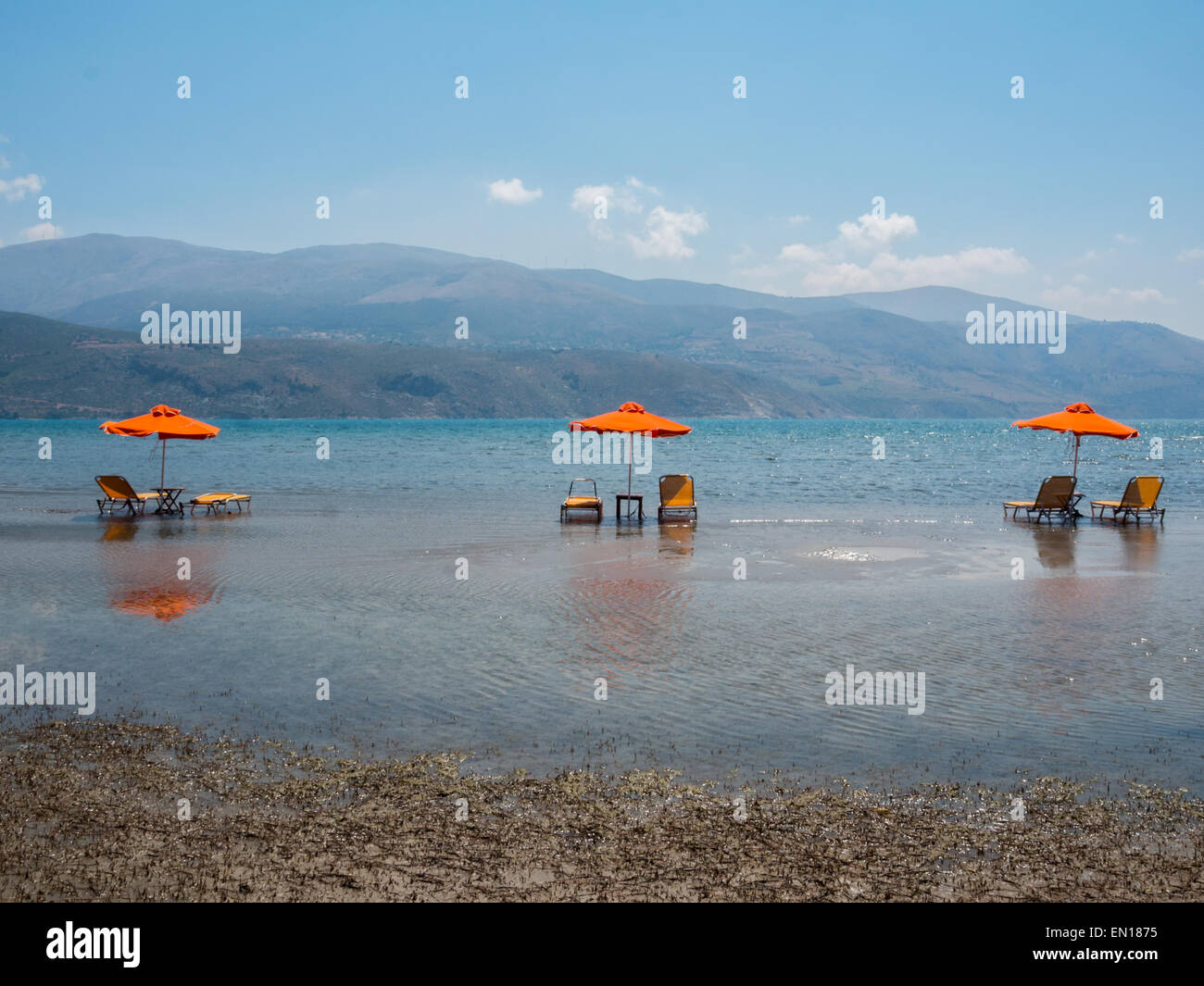 Sun beds and umbrellas in the water at Argostoli beach Stock Photo - Alamy