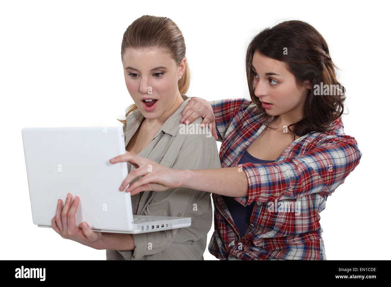 Two shocked girls looking at laptop Stock Photo - Alamy