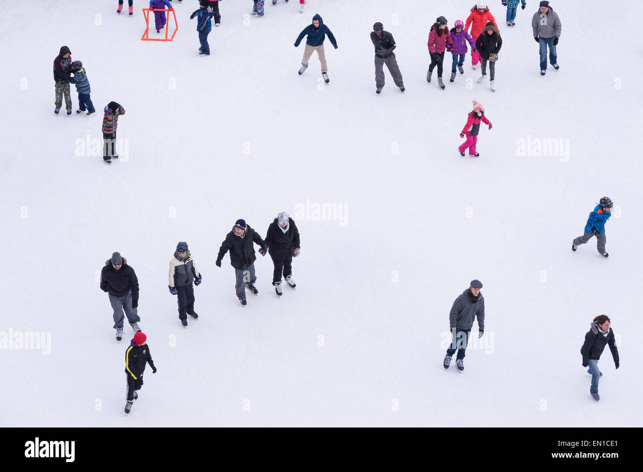 Aerial view of people skating in community rink during winter holiday ...