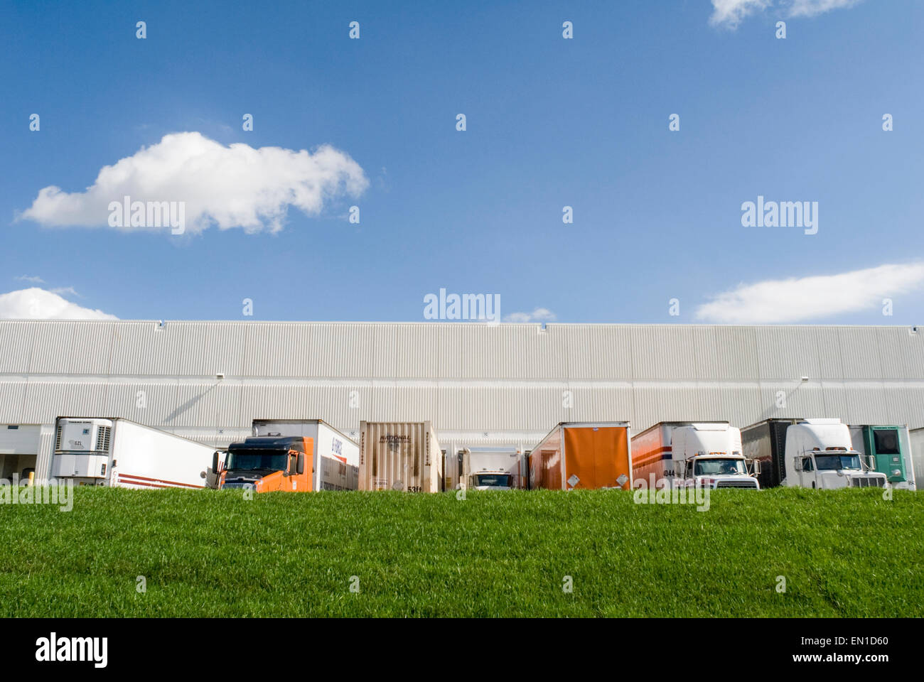 Logistics building, trucks & containers being loaded Stock Photo - Alamy
