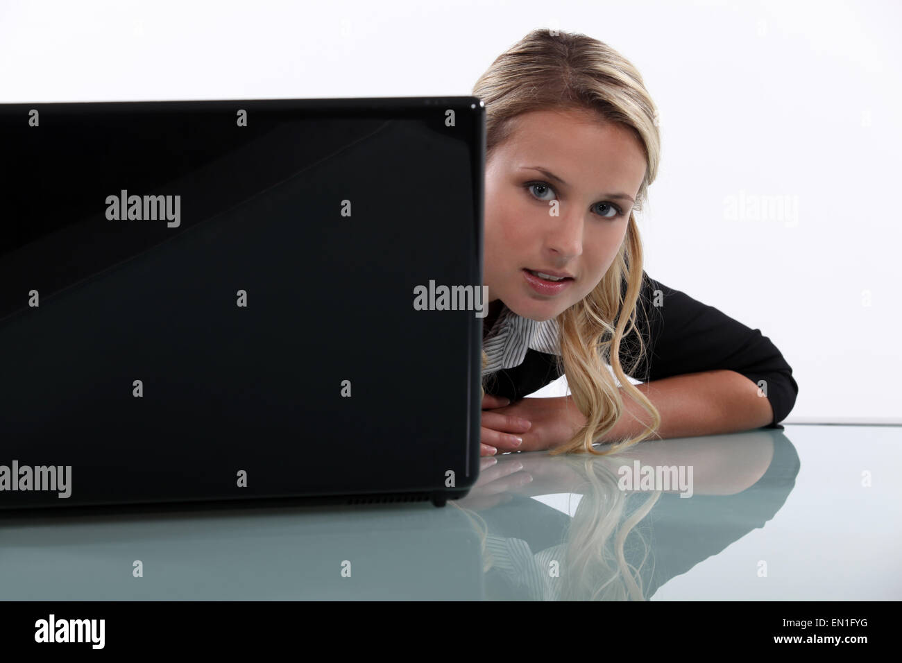 Woman peeking round a laptop Stock Photo - Alamy