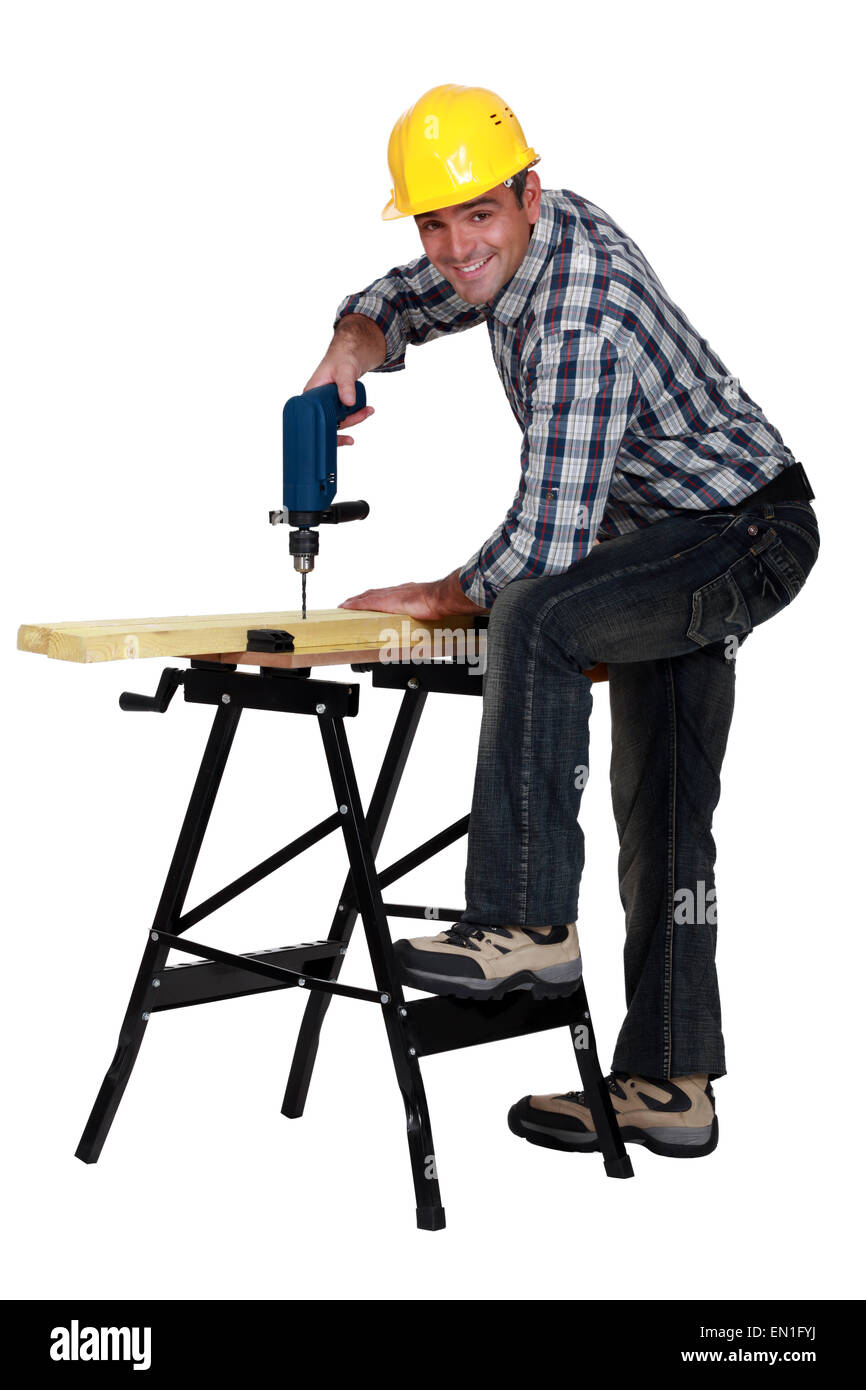 Man using a drill at a workbench Stock Photo - Alamy