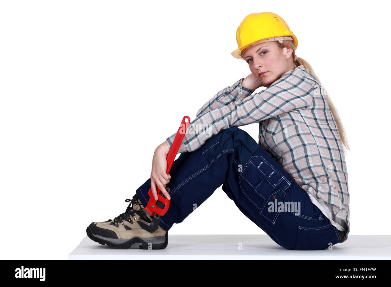 Woman sat holding wrench Stock Photo - Alamy