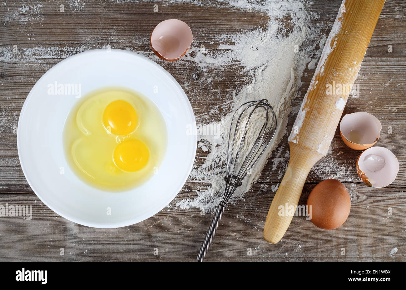 Cooking background with eggs, raw eggs in a dish, eggshells, flour ...