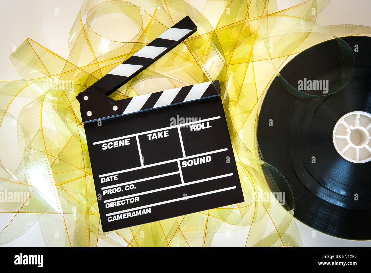 Empty yellow 35 mm film unrolled with clapper board and cinema movie ...