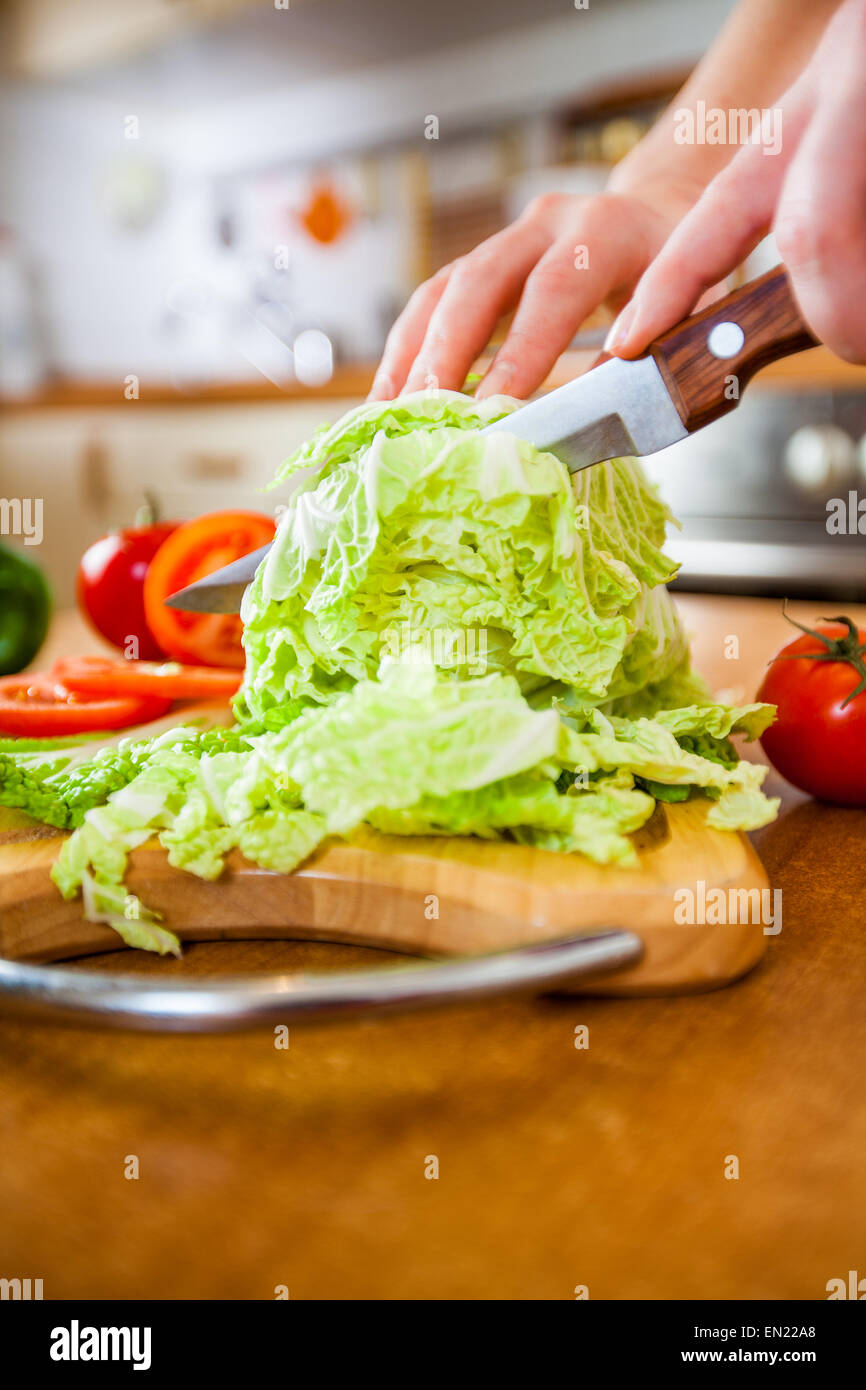 Woman's hands cutting lettuce, behind fresh vegetables Stock Photo - Alamy