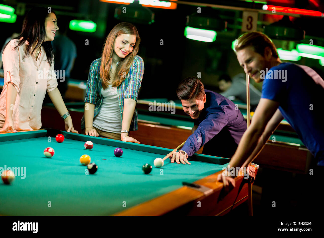 Young people playing pool Stock Photo - Alamy