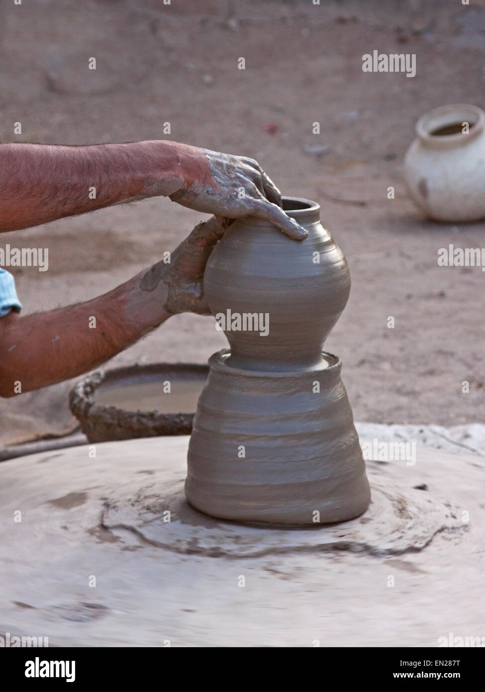 A village potter creating a new vessel using traditional techniques ...
