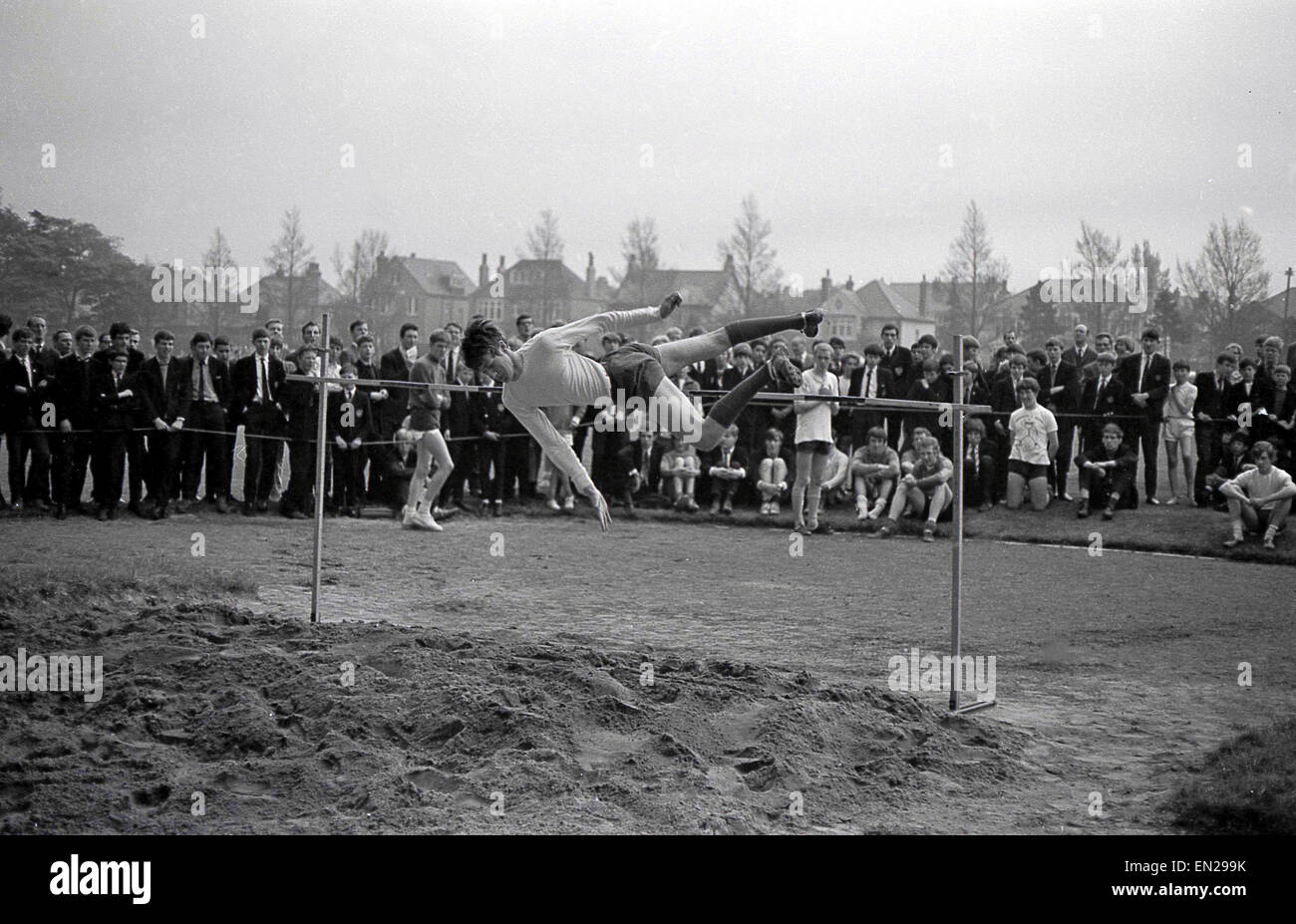 1960s historical picture from a school sports day of a pupil attempting ...