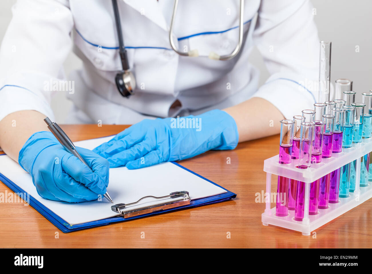 doctor write beside test tubes standing on a light background Stock ...