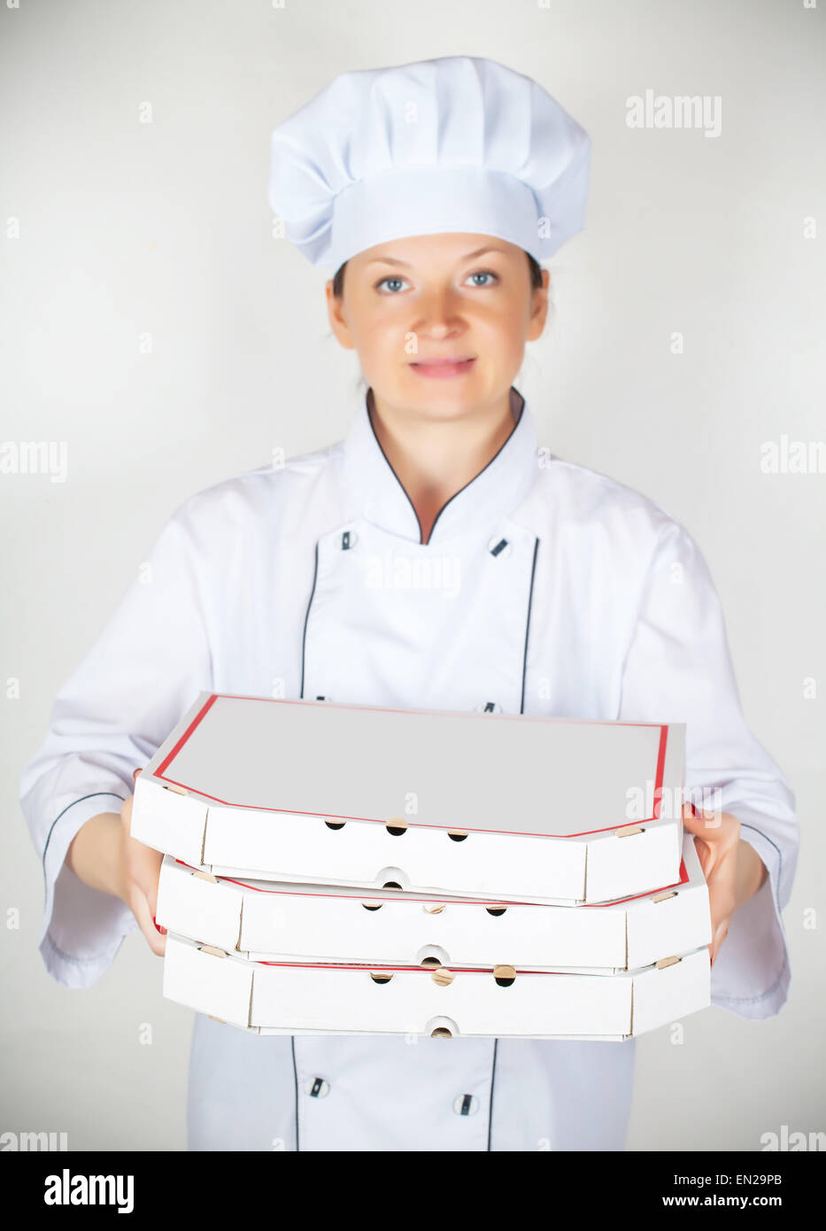 cook with a pizza in the box on a light background Stock Photo - Alamy