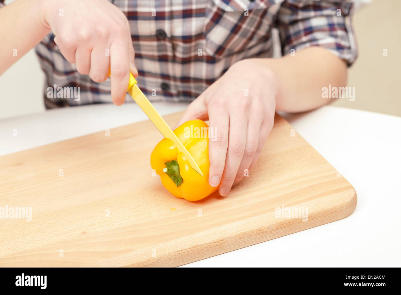 yellow pepper being cut on slicing board Stock Photo - Alamy