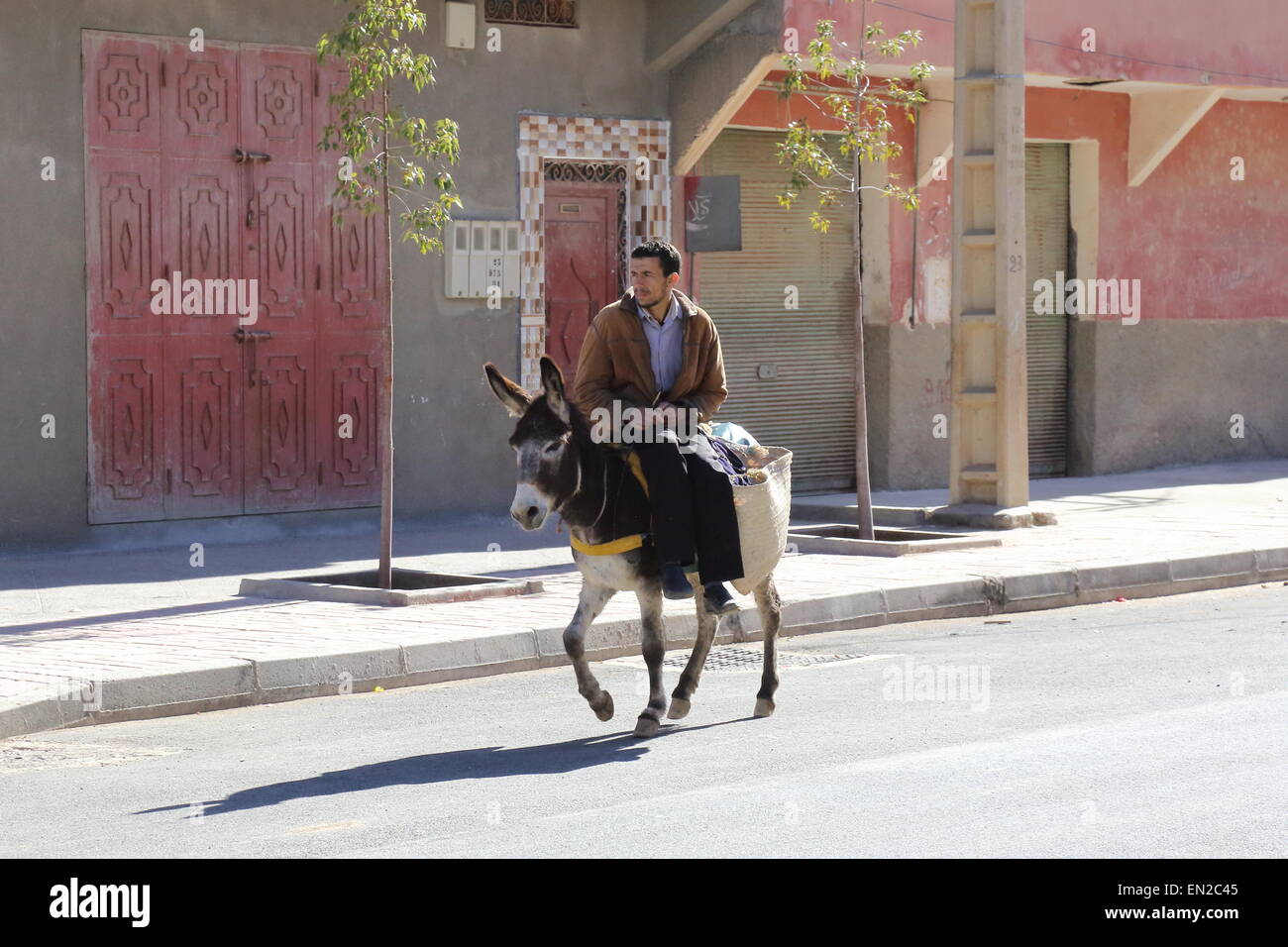 A Berber man rides his donkey on the streets of Amizmiz at the foot of ...