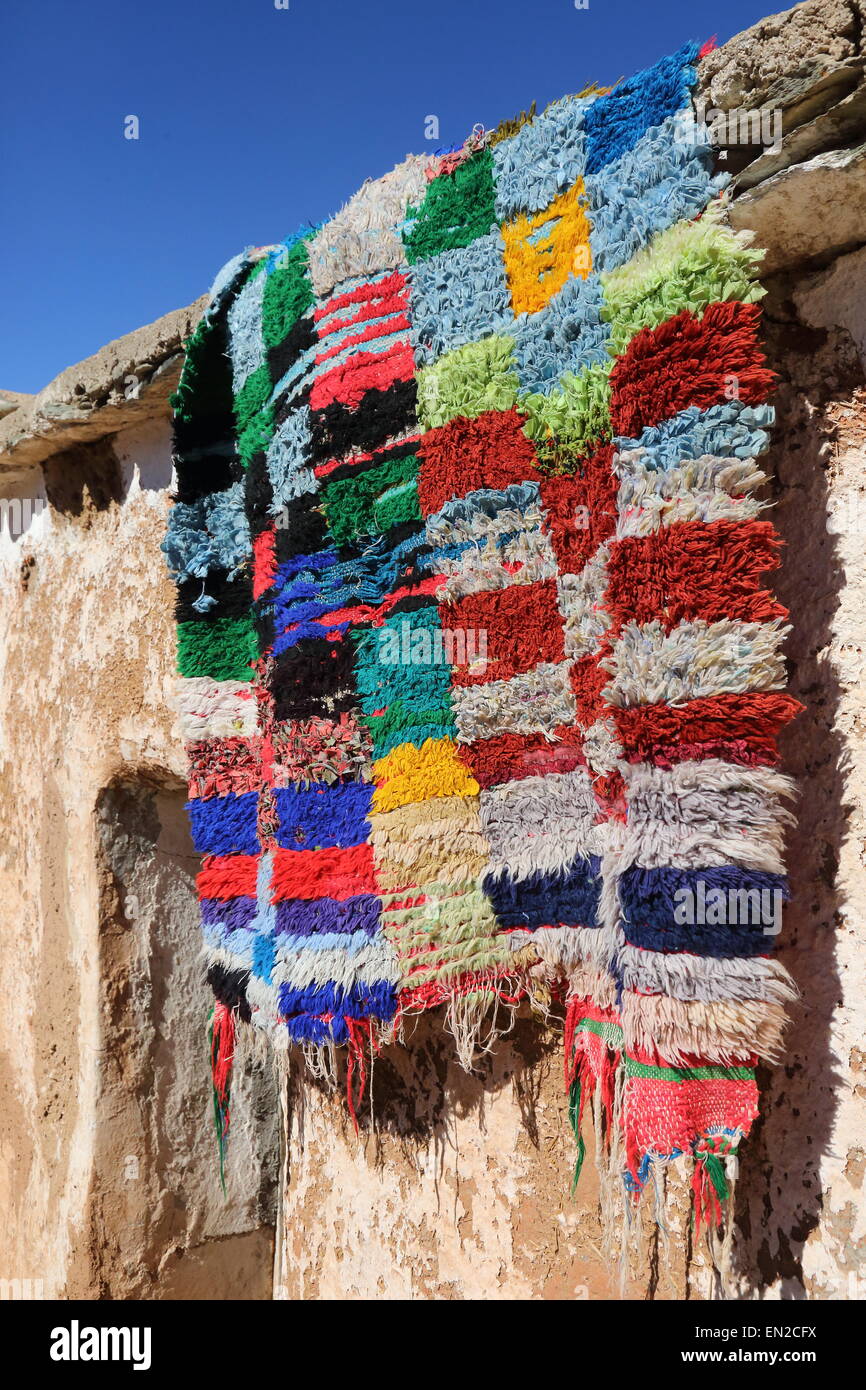 A traditional colourful Berber rug hanging on the wall inside a Berber ...
