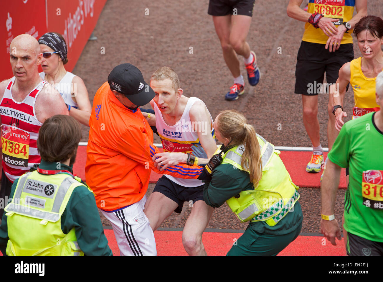 A runner collapses at the finish line of the Virgin money London ...