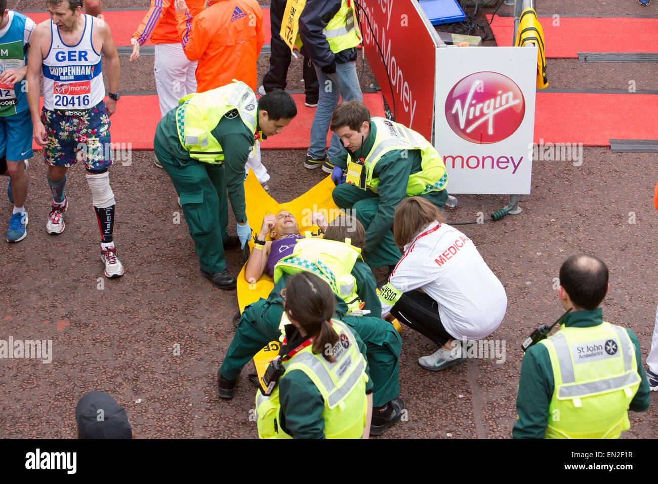 A medical team stretcher a runner away from the finish line at the ...