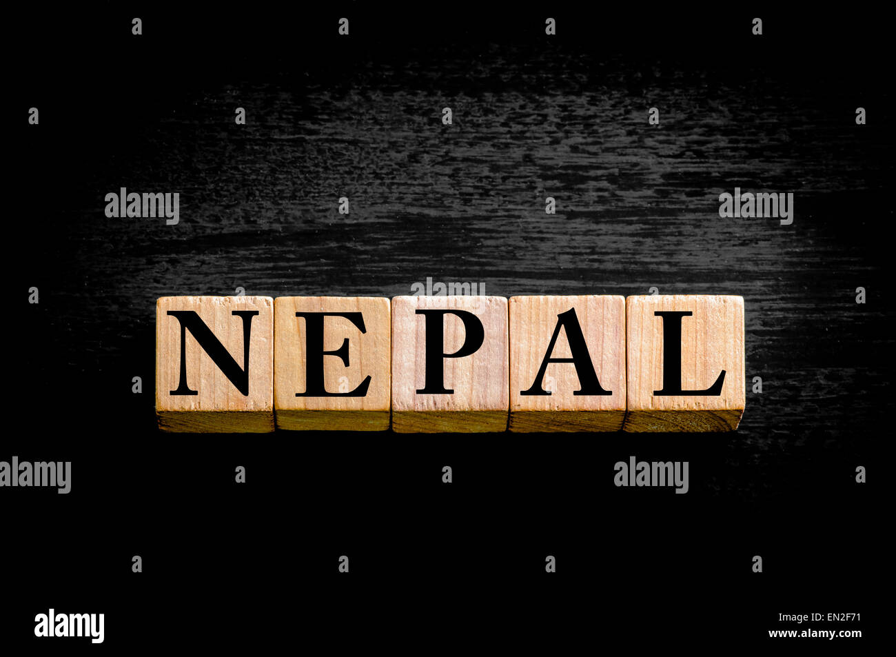 Word NEPAL. Wooden small cubes with letters isolated on black ...
