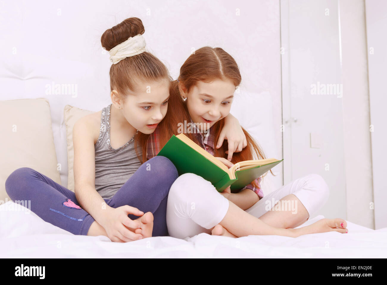 Pair of little girls reading book Stock Photo - Alamy