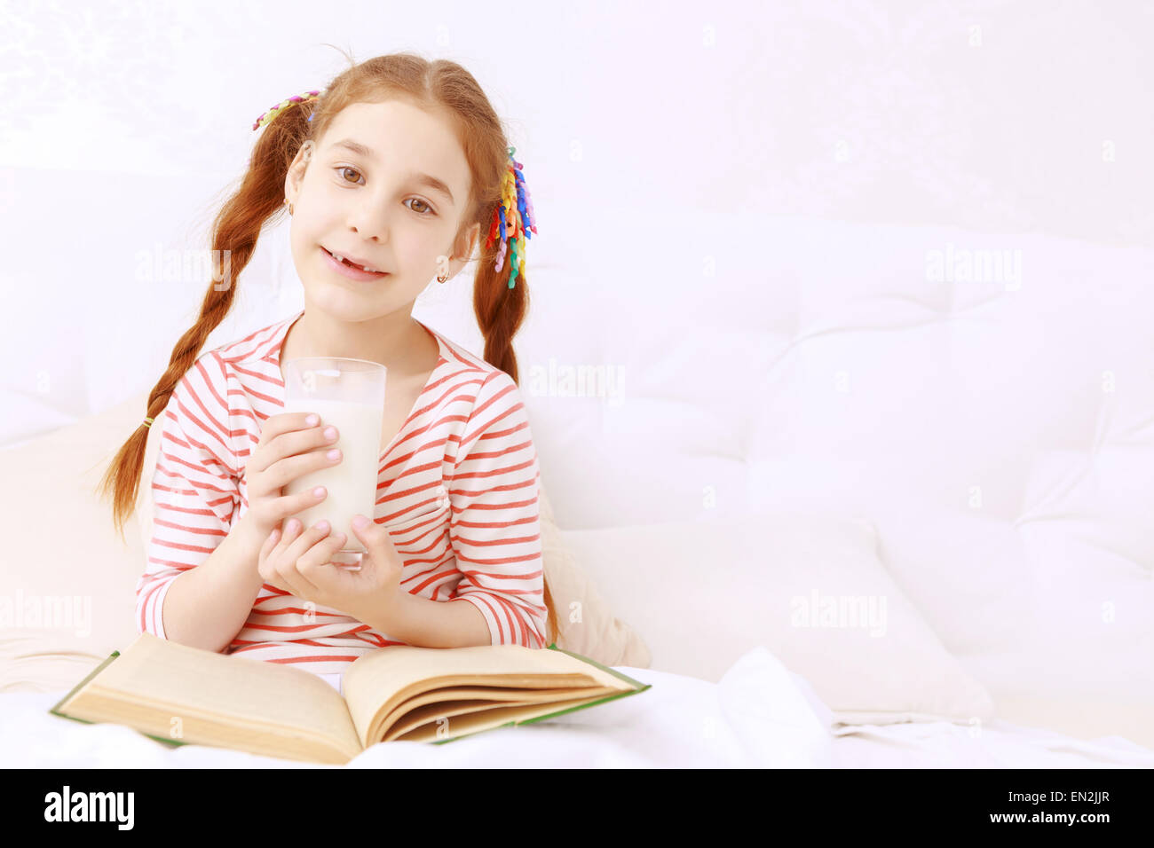 Read-haired girl drinking milk and reading Stock Photo - Alamy