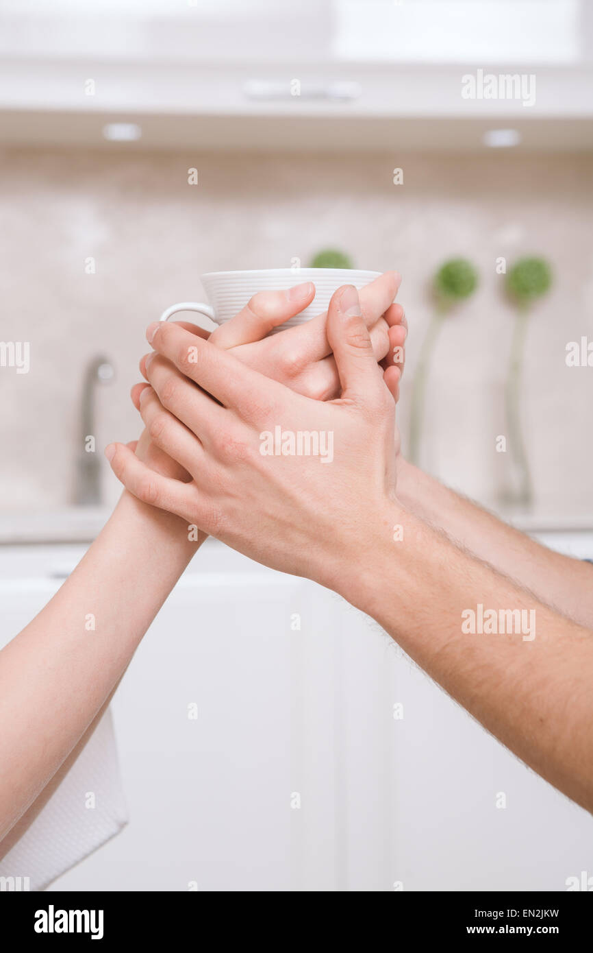 Two people holding cup together Stock Photo - Alamy