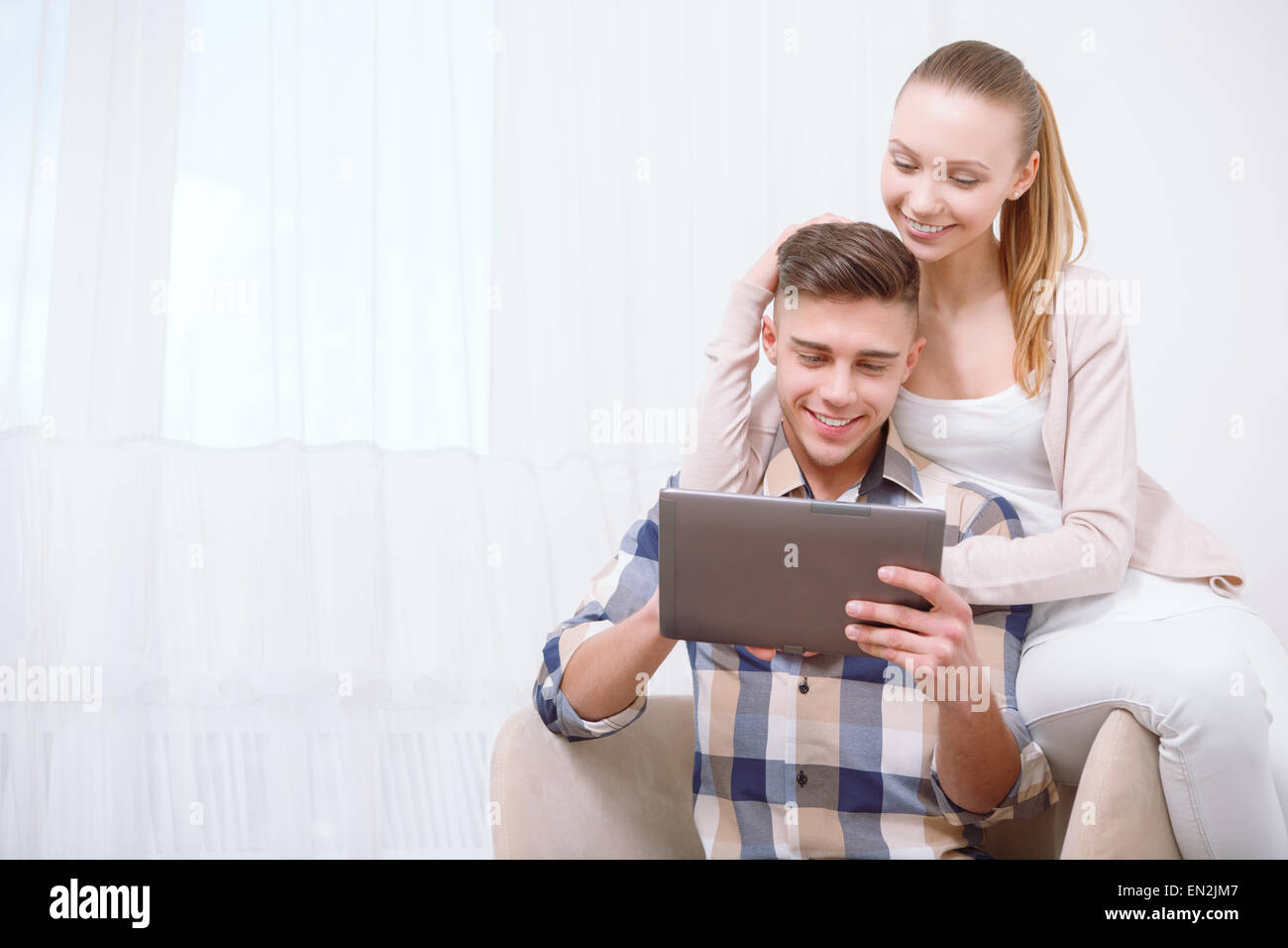 Couple excited using tablet Stock Photo - Alamy