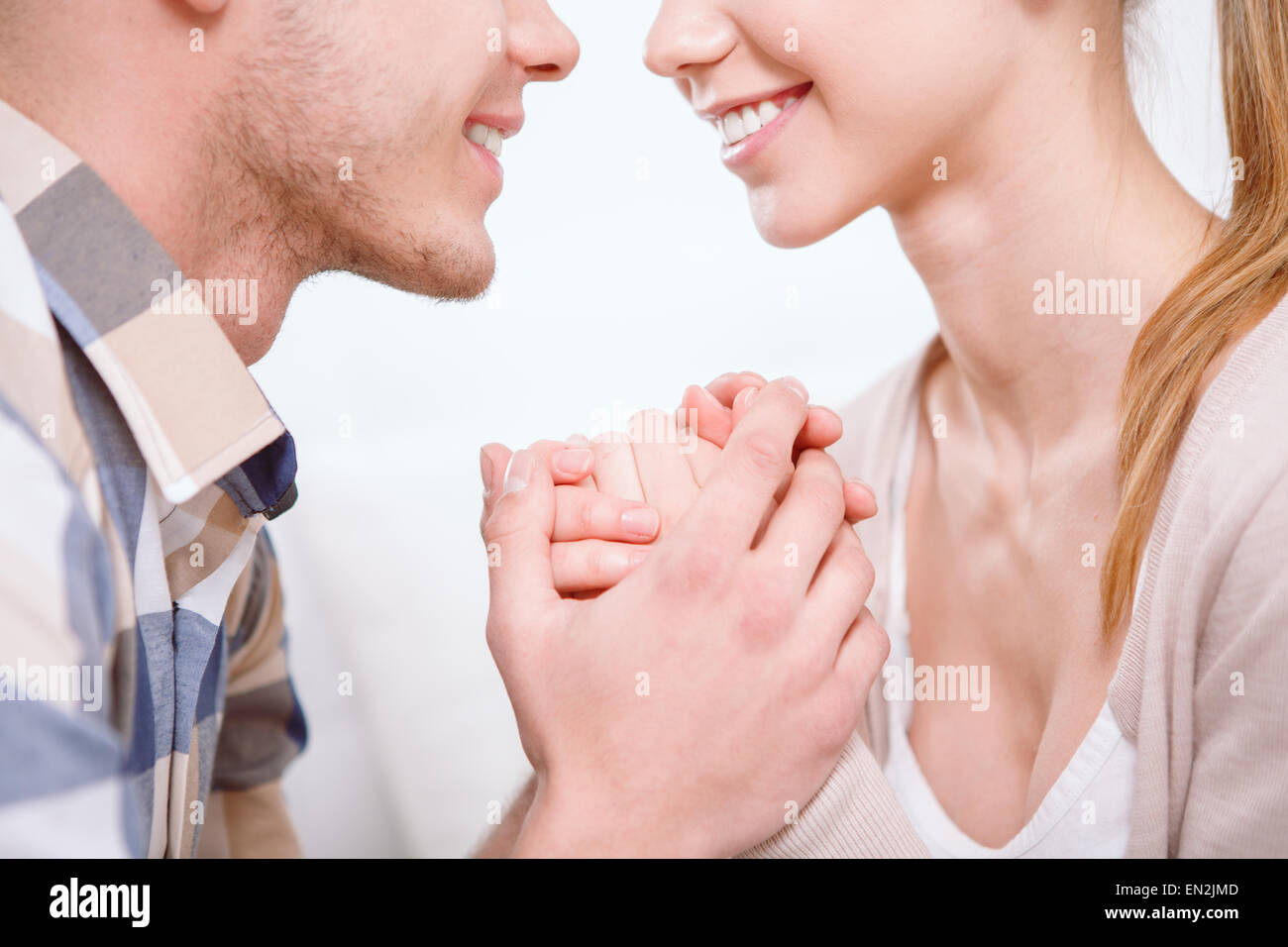 Two young people sitting with embraced hands Stock Photo - Alamy