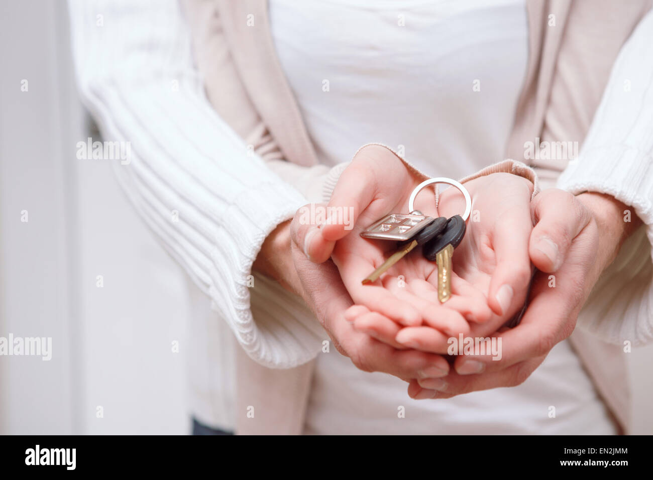 Two people holding keys Stock Photo - Alamy