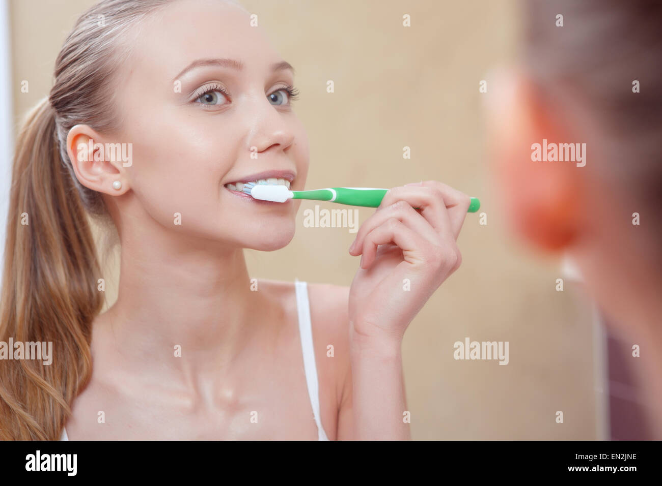 Pretty young woman cleaning her teeth Stock Photo - Alamy