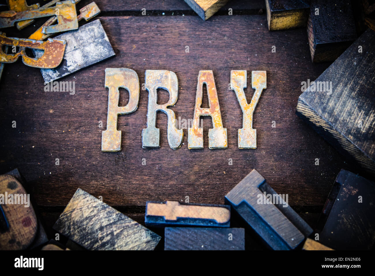 The word PRAY written in rusted metal letters surrounded by vintage ...