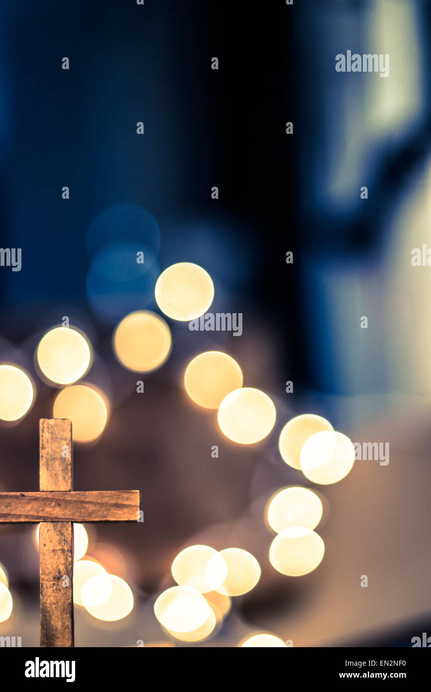 A wooden cross with defocused warm lights in the background Stock Photo ...