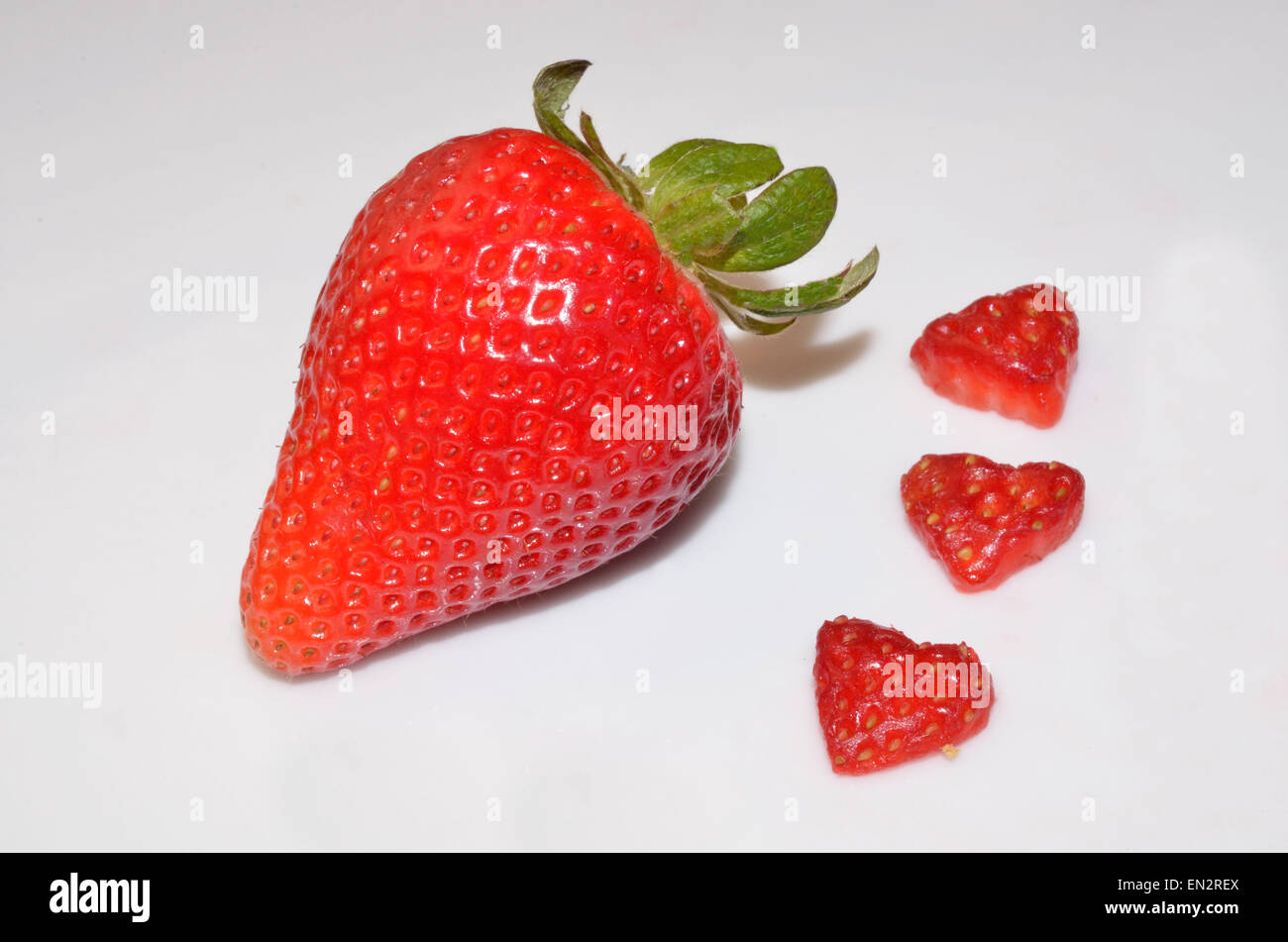 Bright red fresh whole strawberry with heart shaped strawberry cut outs ...