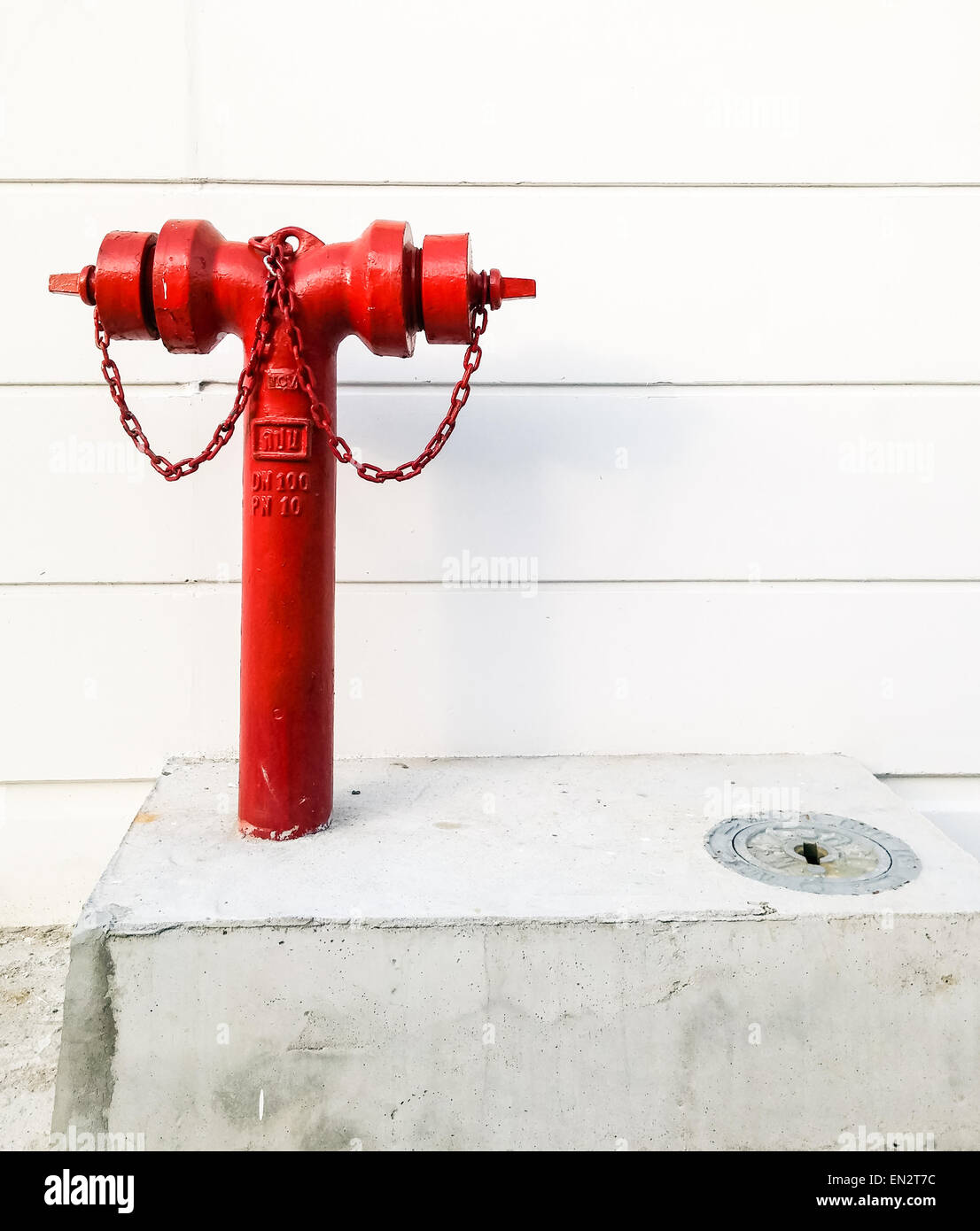 Slim fire hydrant near the wall of urban village Stock Photo - Alamy