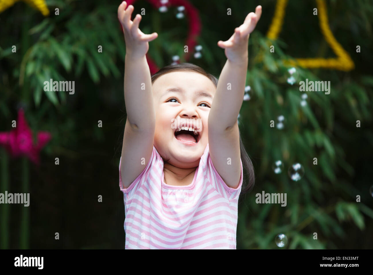 Excited the little girl is playing outdoors Stock Photo - Alamy