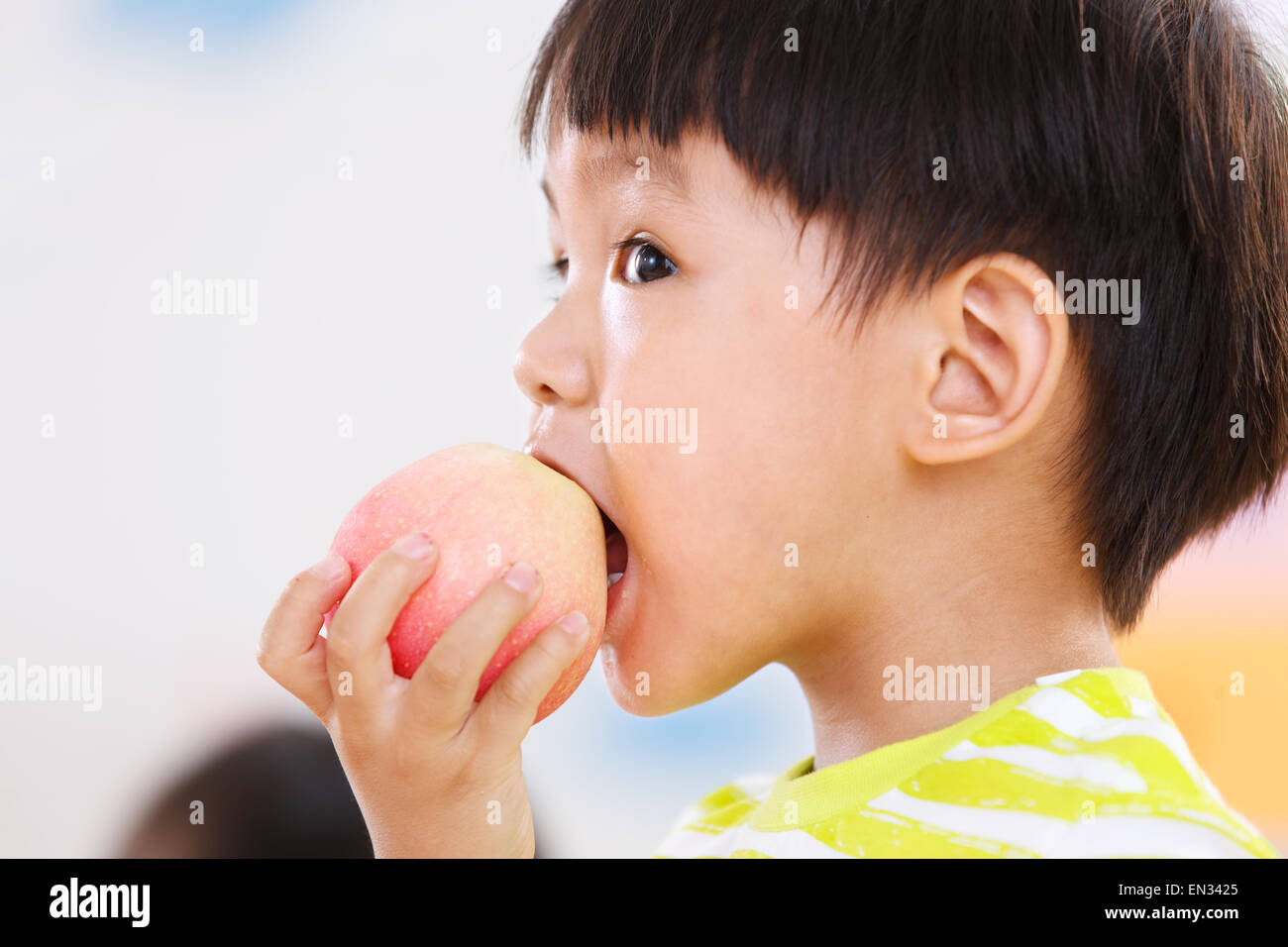 The little boy is eating an apple Stock Photo - Alamy