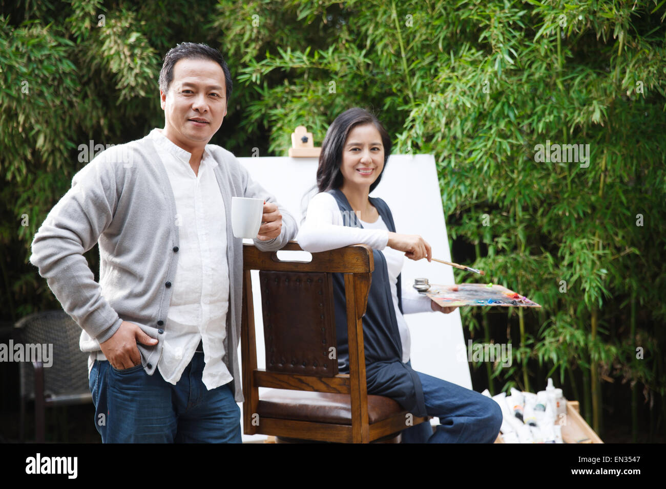 The artist couple painting in the courtyard Stock Photo - Alamy