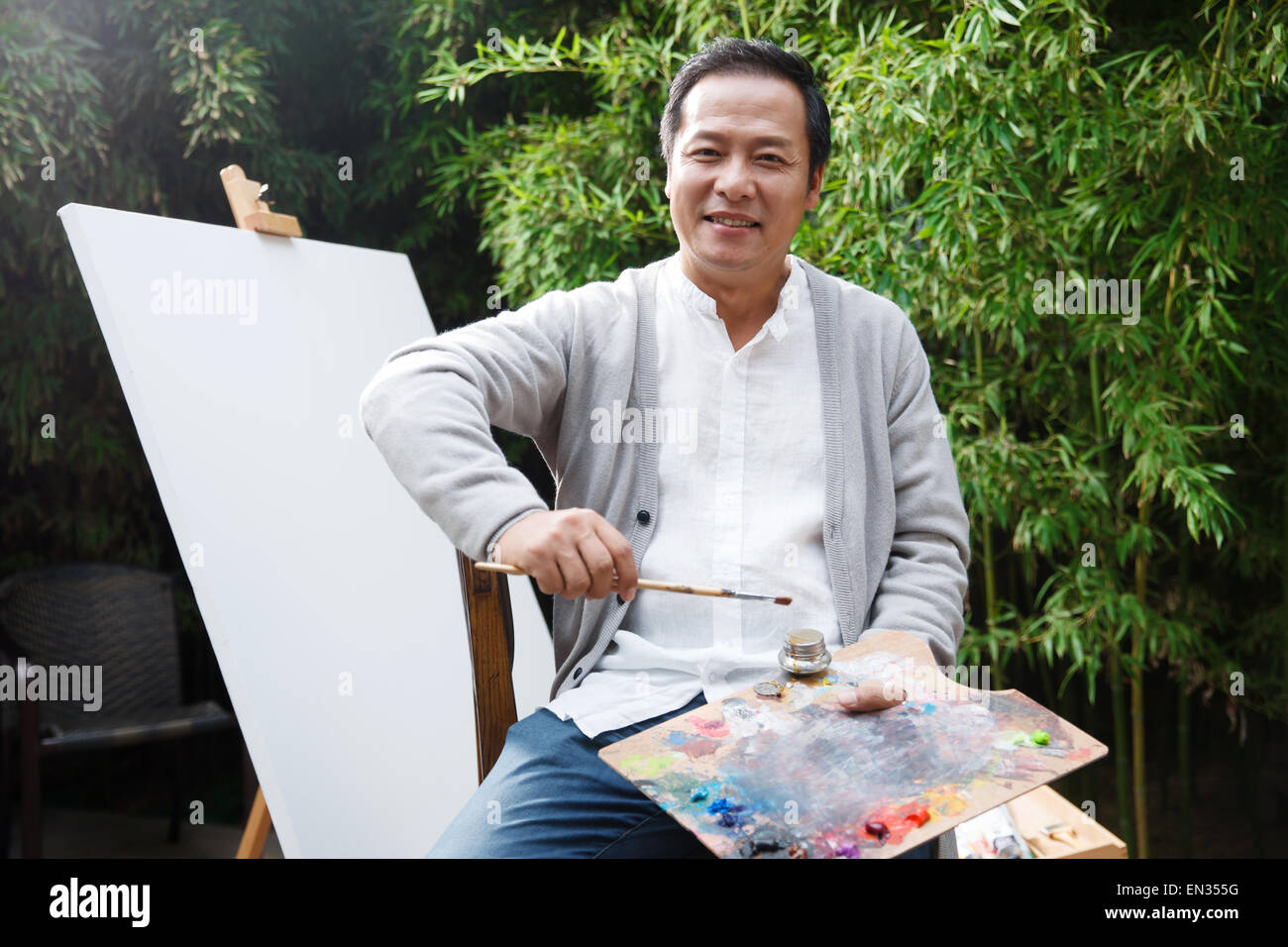 Male artist is painting in the yard Stock Photo - Alamy