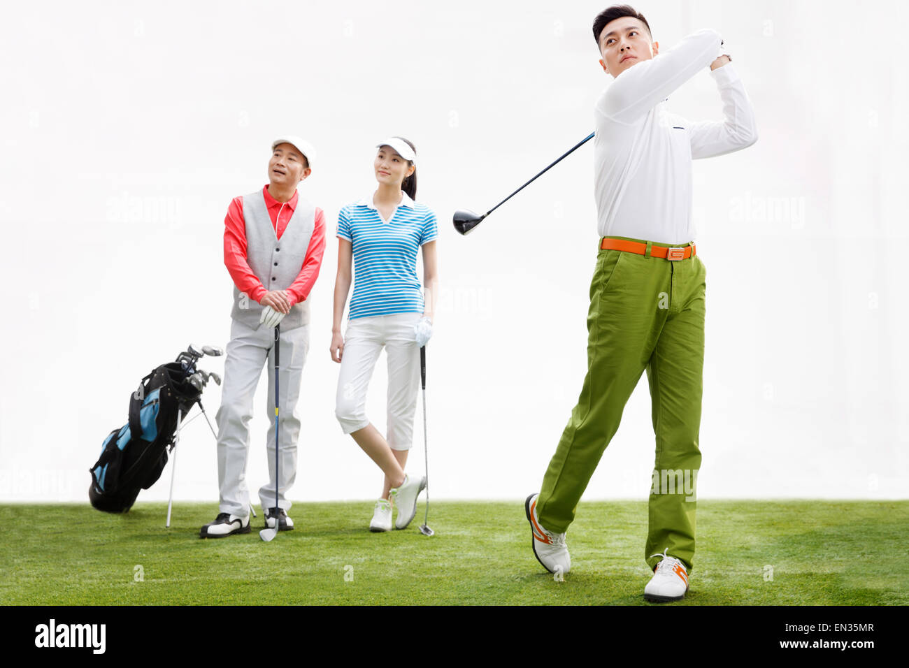 Young people playing golf Stock Photo - Alamy