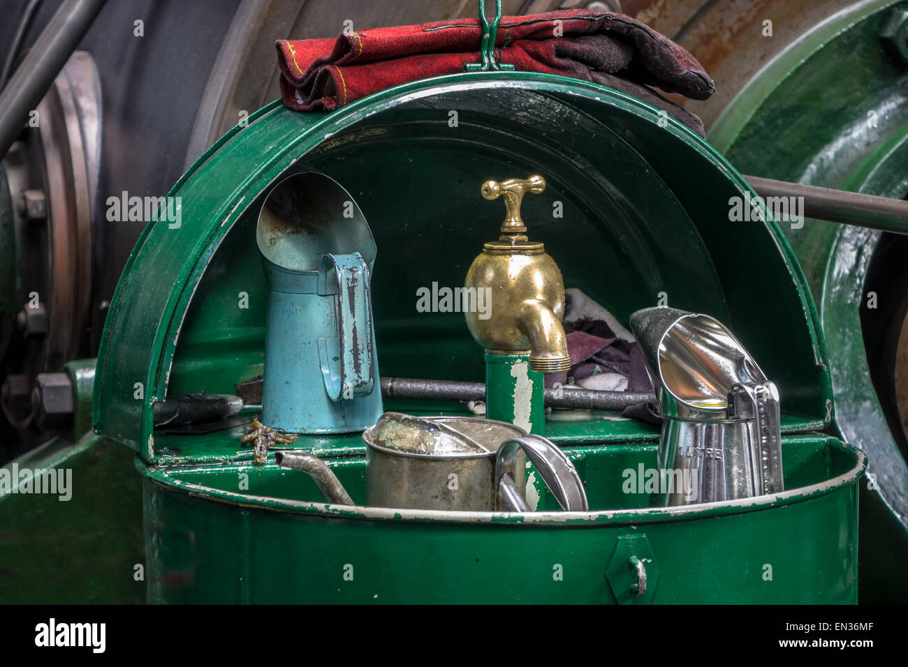 An old brass oil tap with cans in an engineer workshop Stock Photo - Alamy