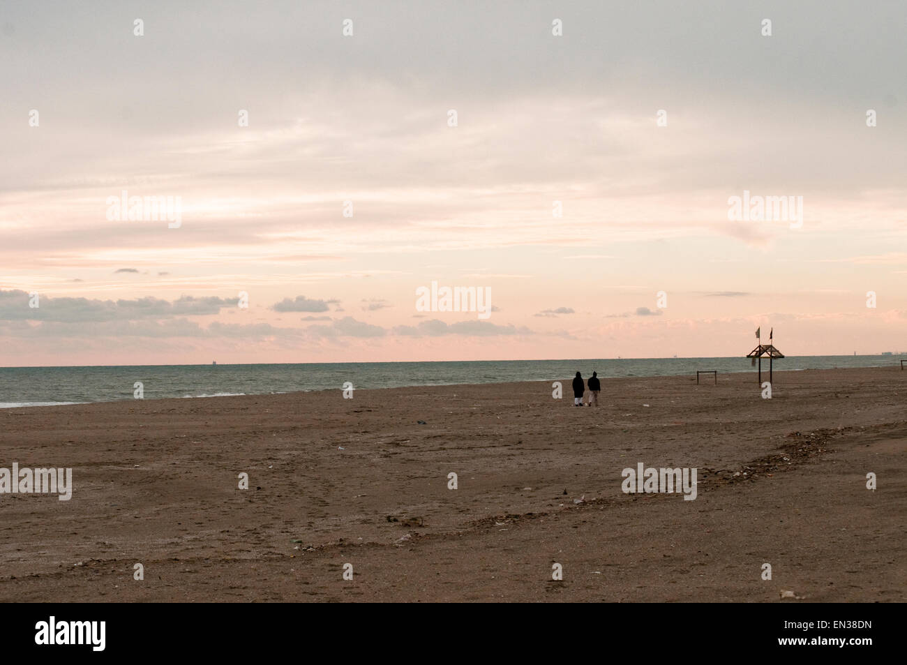 Two men walking on the sand Stock Photo - Alamy