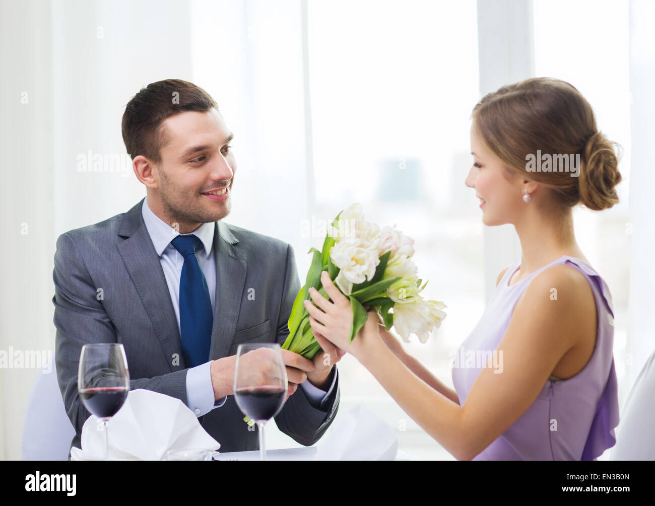 smiling man giving flower bouquet at restaurant Stock Photo - Alamy