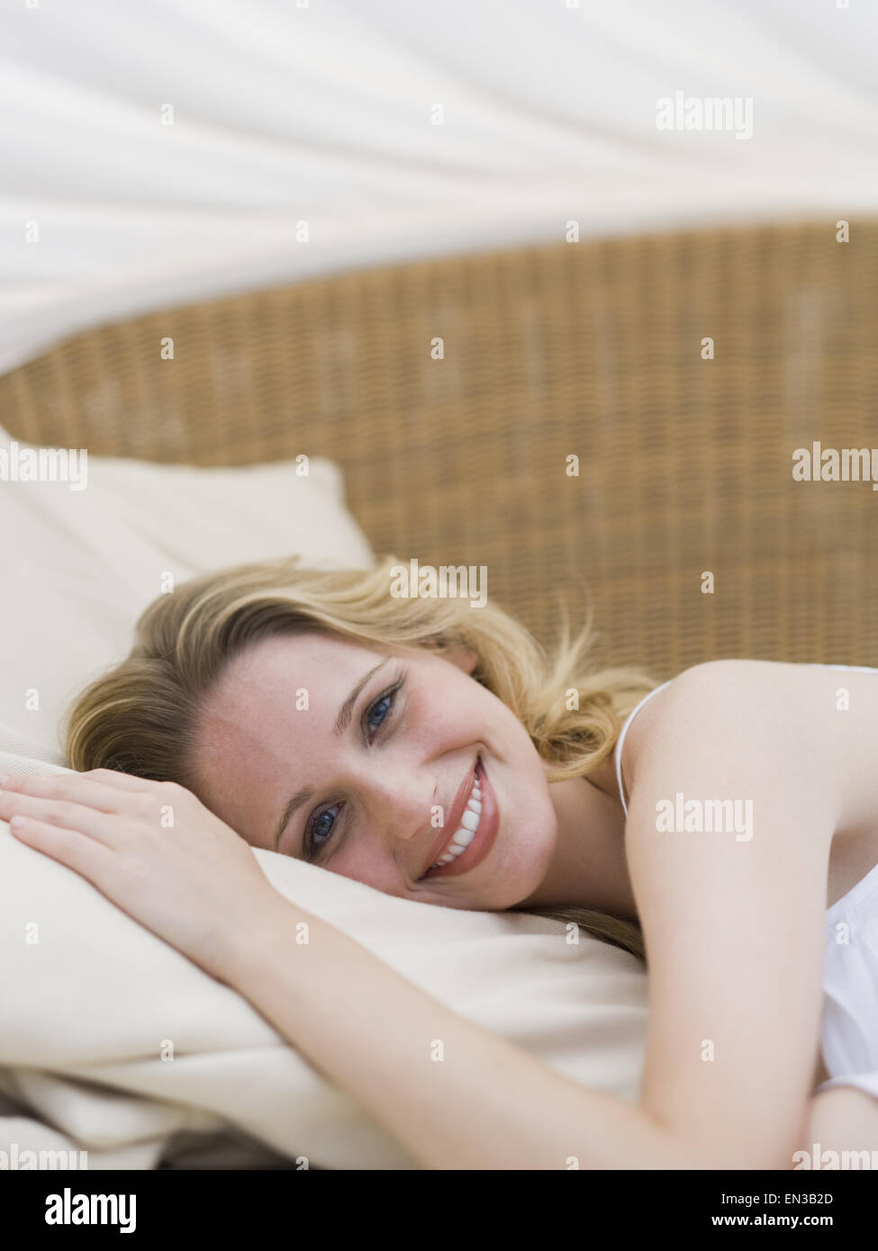 Woman lying down on lounge chair smiling Stock Photo - Alamy