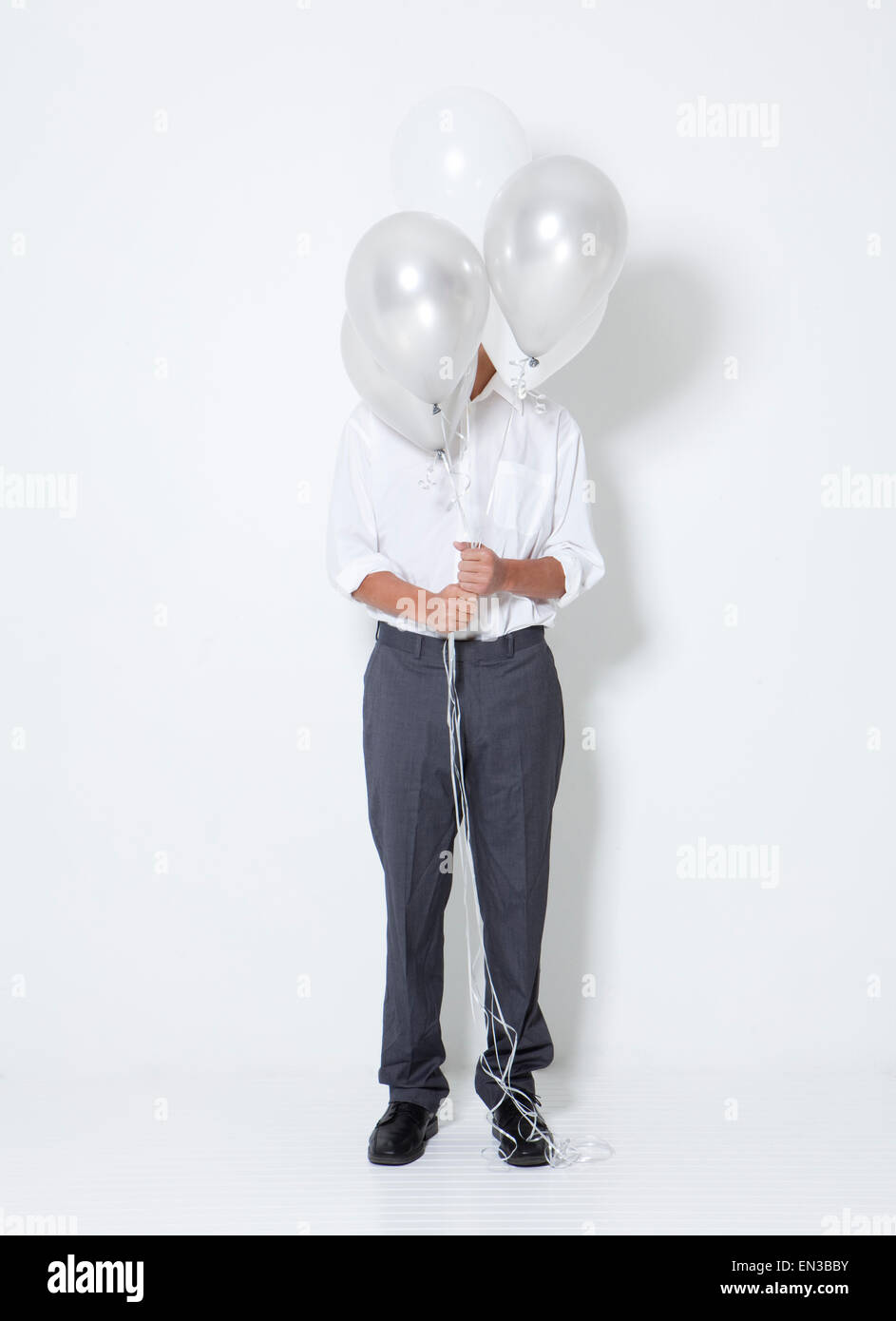 Young man hiding behind balloons at party Stock Photo - Alamy