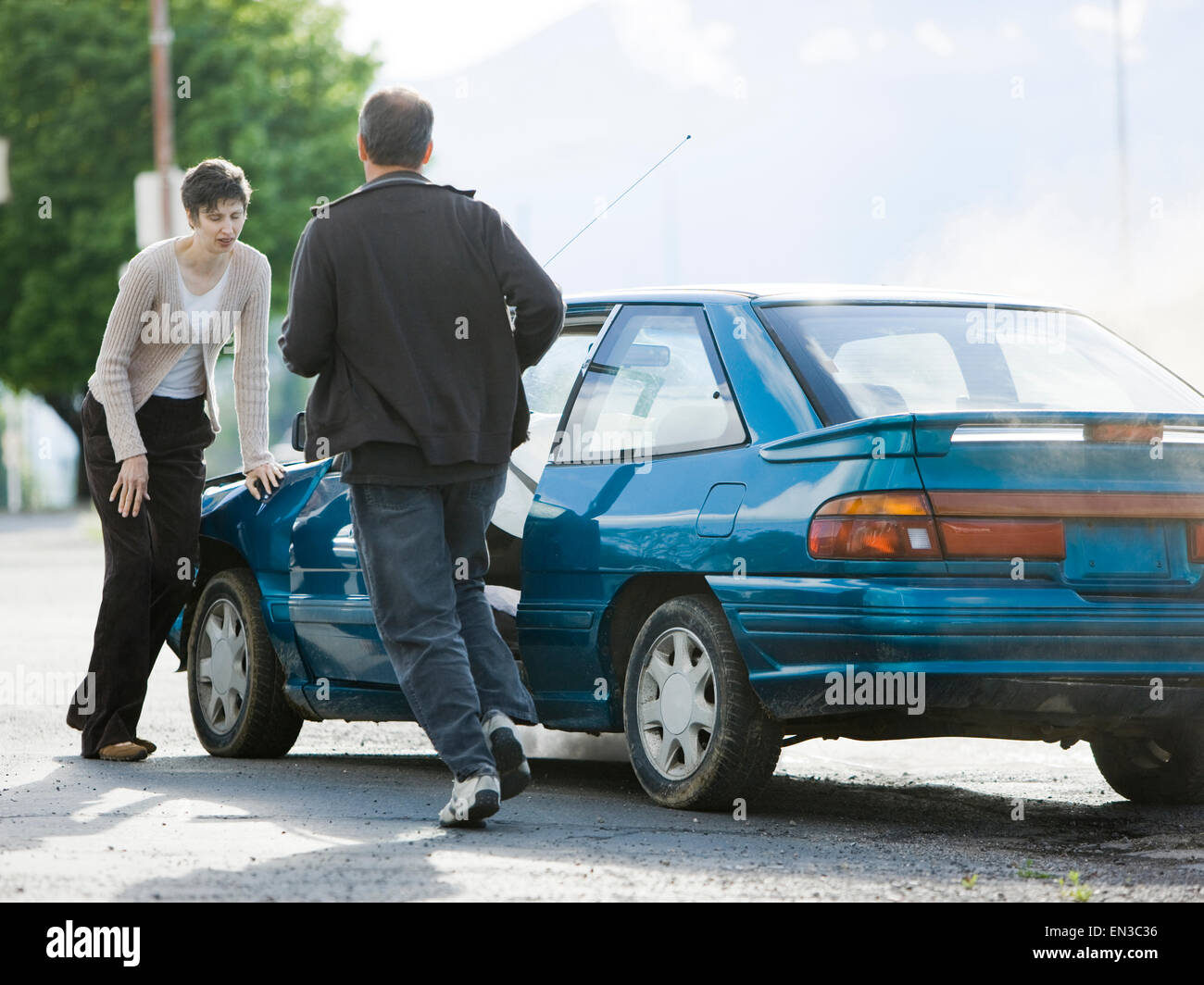 man helping a woman after a car accident Stock Photo - Alamy