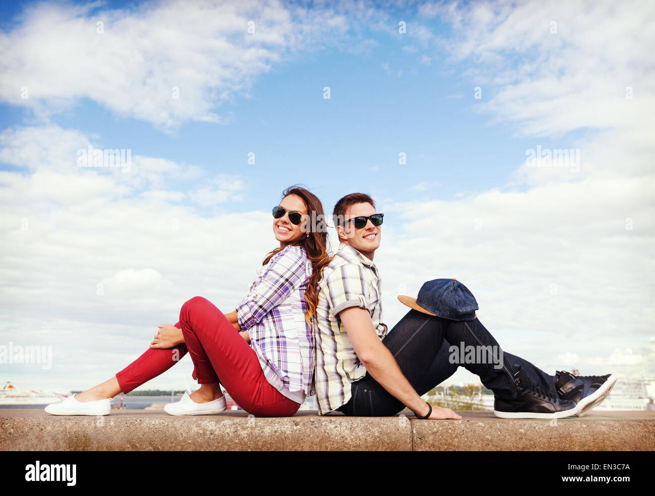 teenagers sitting back to back Stock Photo - Alamy
