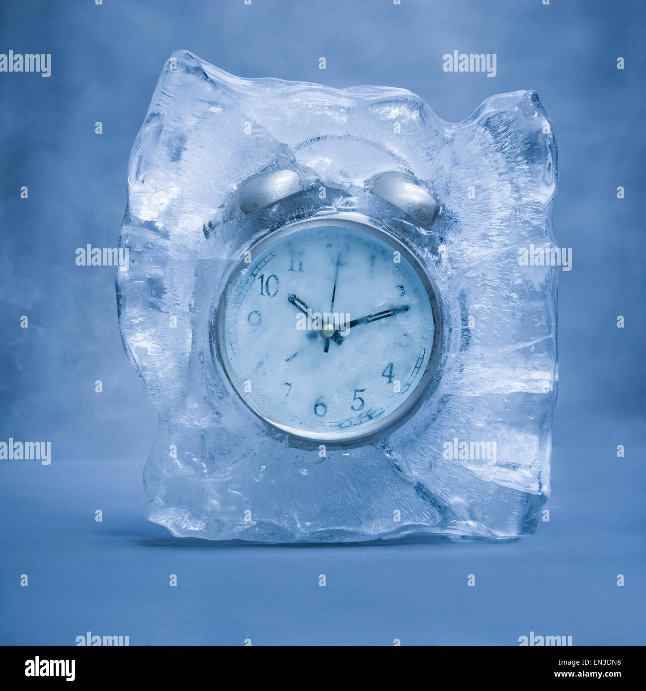 alarm clock in a block of ice Stock Photo - Alamy