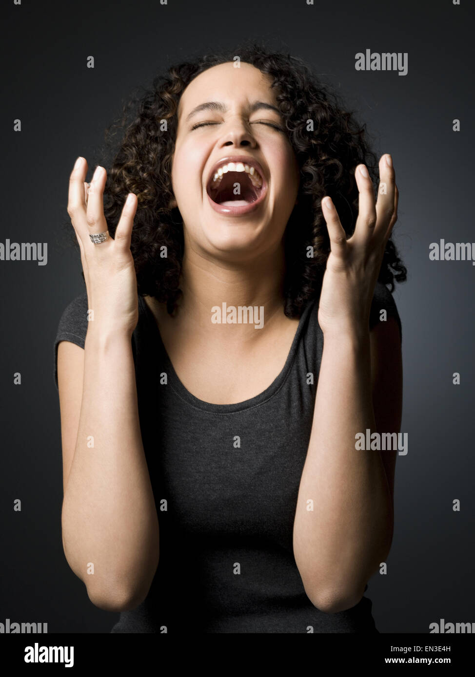 Woman with mouth open and closed eyes with hands on face Stock Photo ...