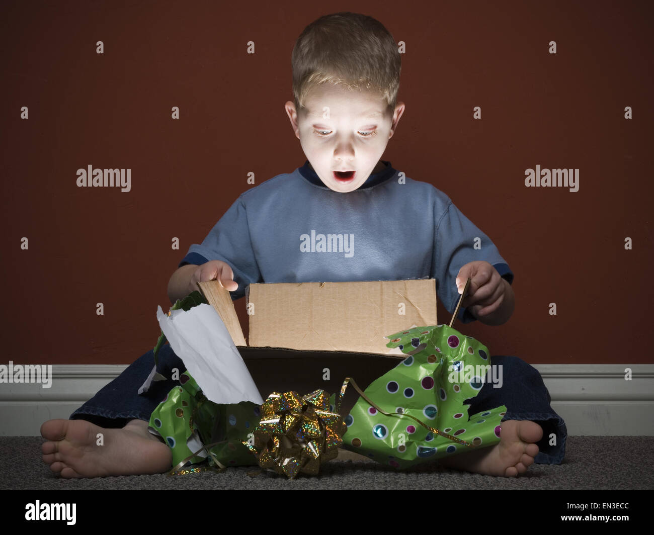 Young boy opening present Stock Photo - Alamy